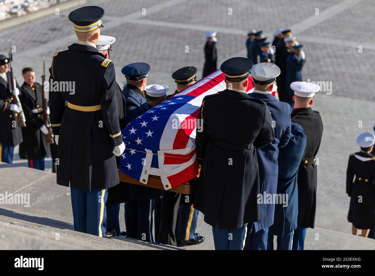 A joint services body bearer team carries the flag-draped casket of ...