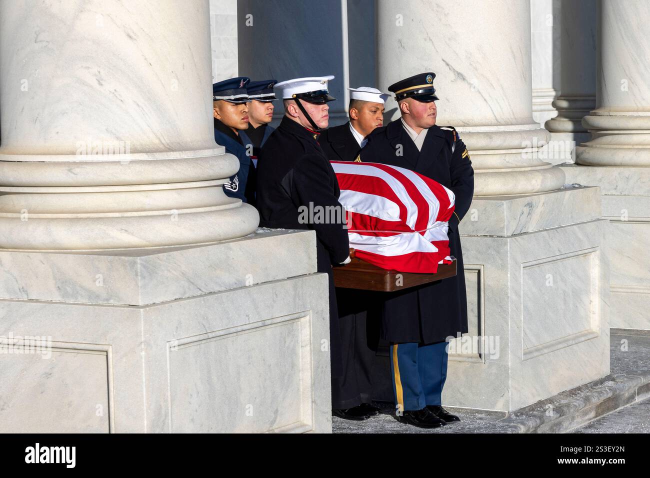 A joint services body bearer team carries the flag-draped casket of ...