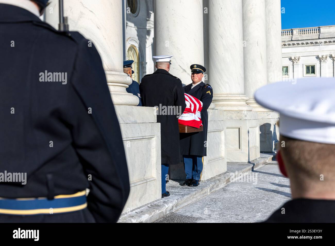 A joint services body bearer team carries the flag-draped casket of ...