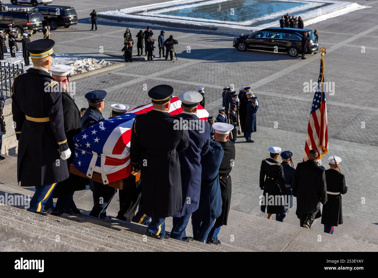 A joint services body bearer team carries the flag-draped casket of ...