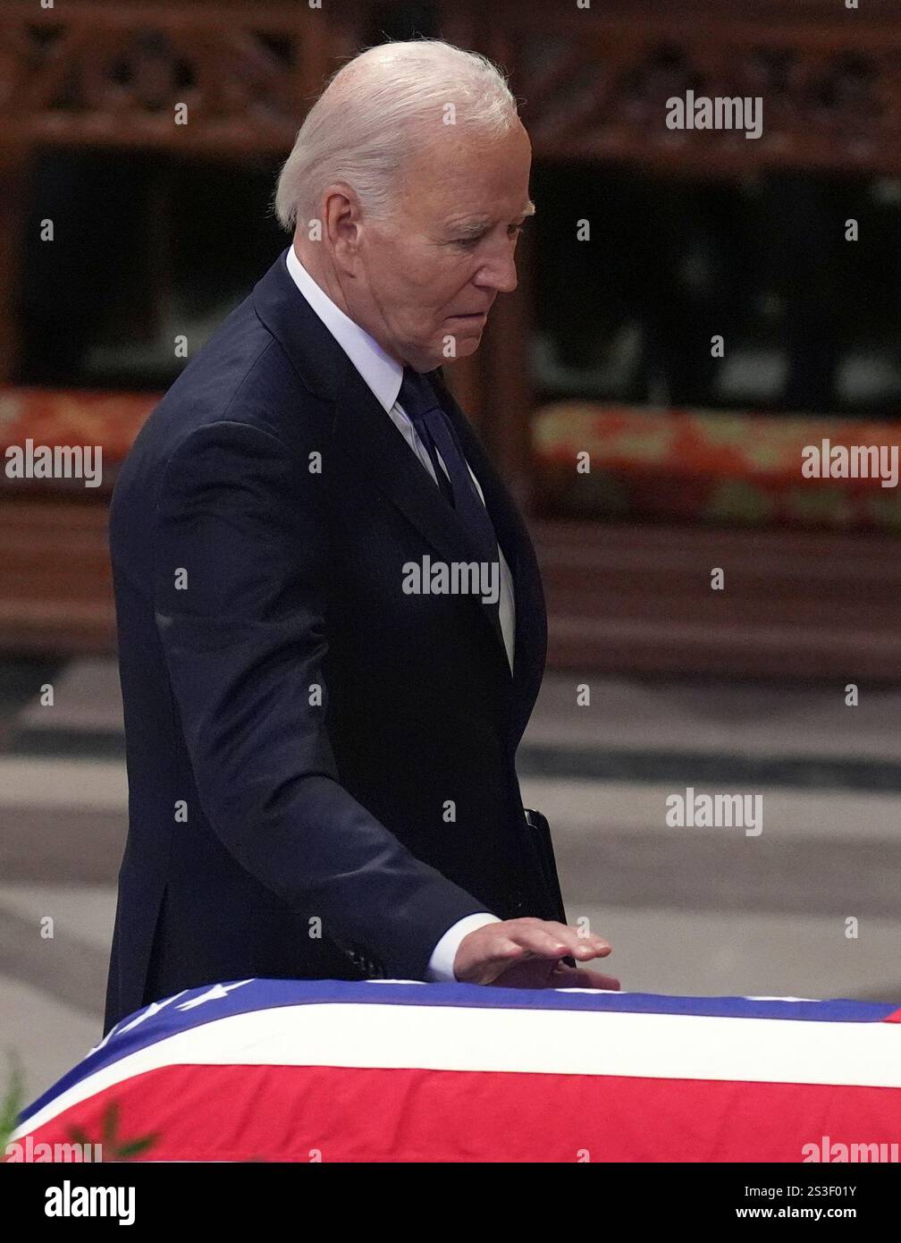 President Joe Biden touches the casket of former President Jimmy Carter ...