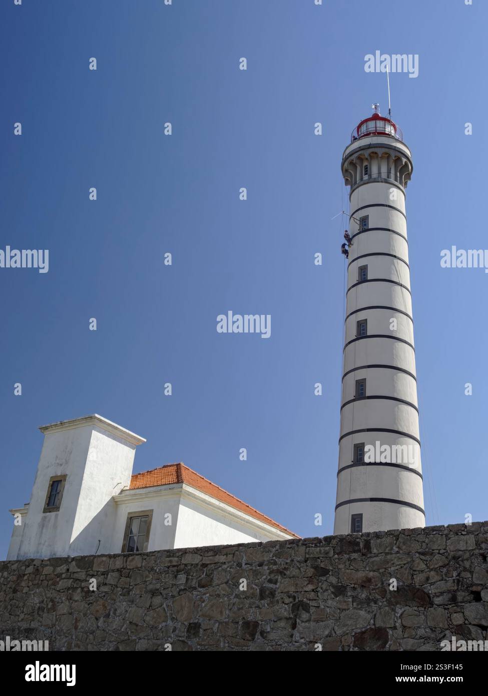 Professional climbers working in the maintenance of a high lighthouse ...