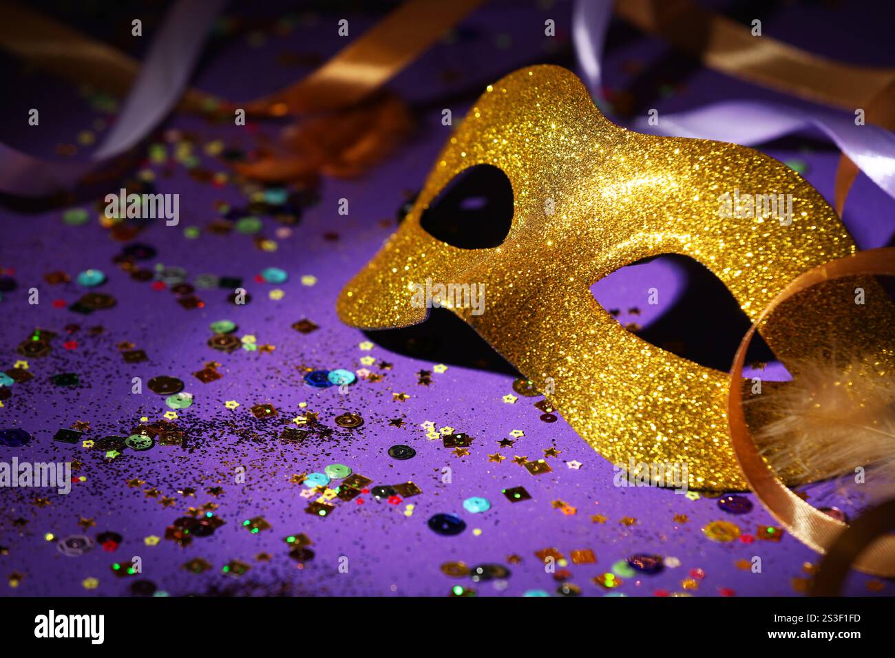 Beautiful carnival mask, ribbons and confetti on purple background ...