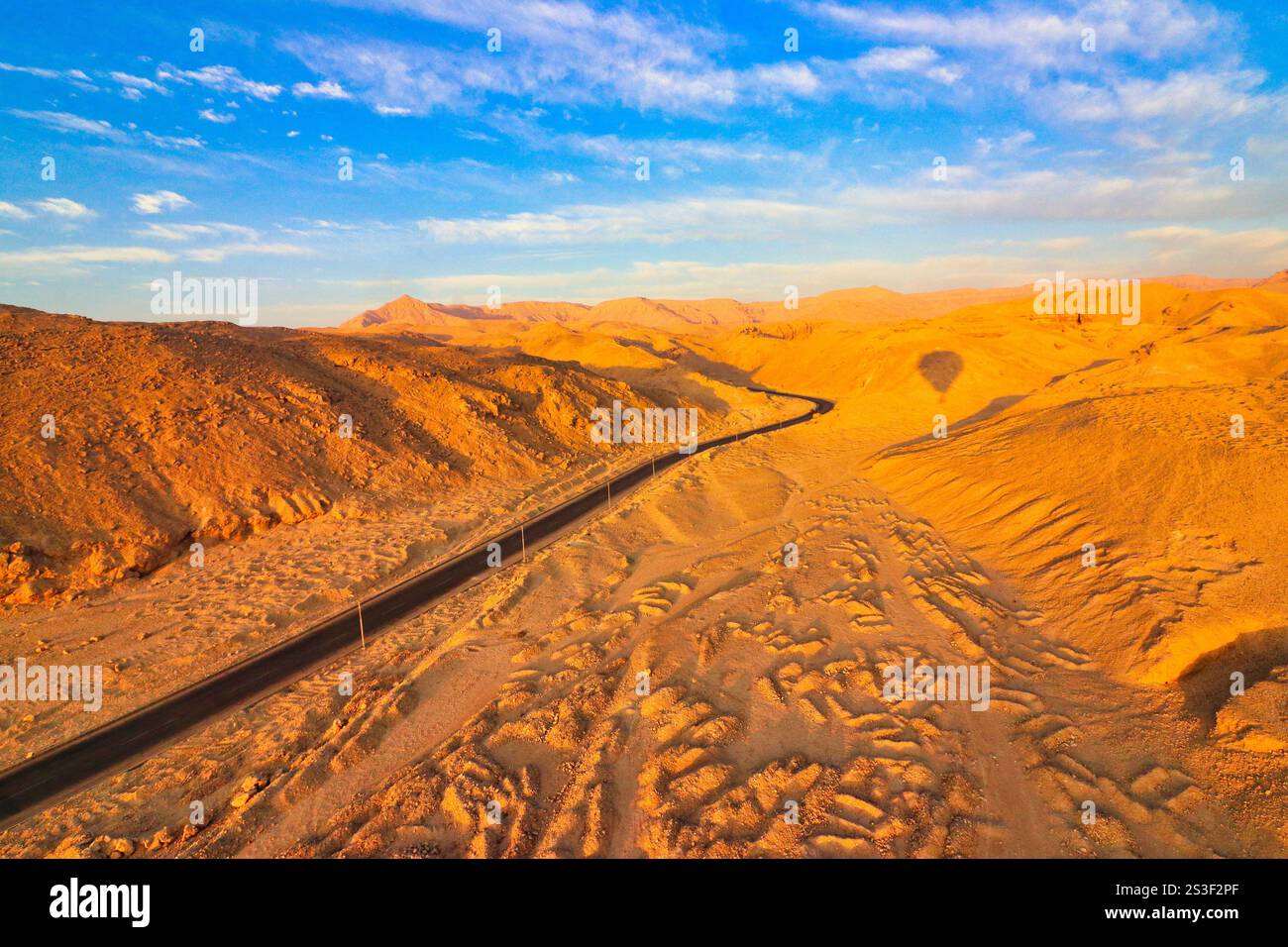 Shadow of a hot air balloon over ochre coloured desert landscapes near ...