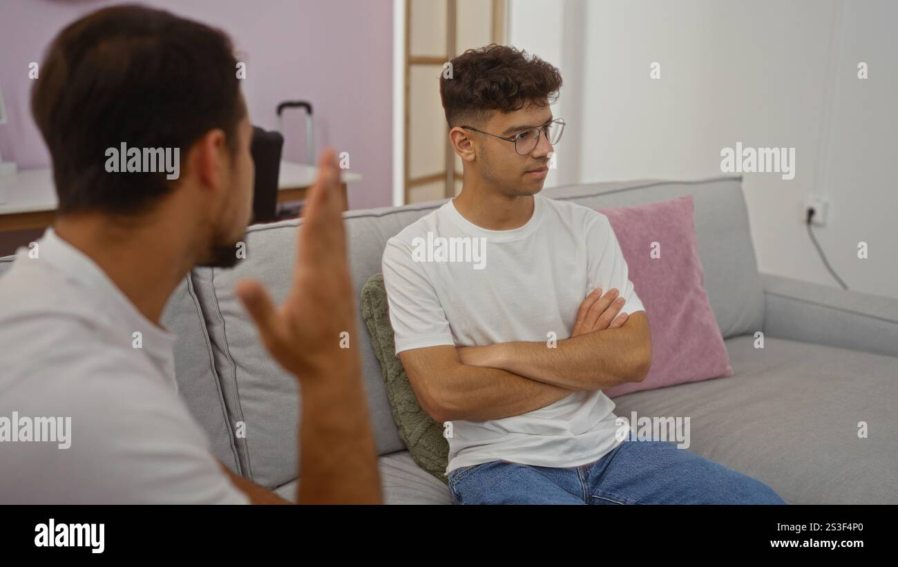 Father and son having a serious conversation in the living room of ...