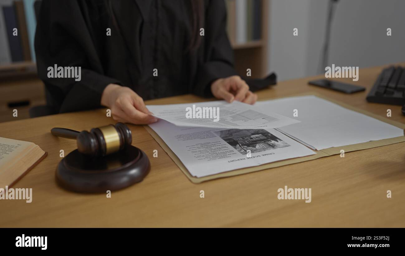 Judge woman reviewing documents in office setting with gavel on desk ...
