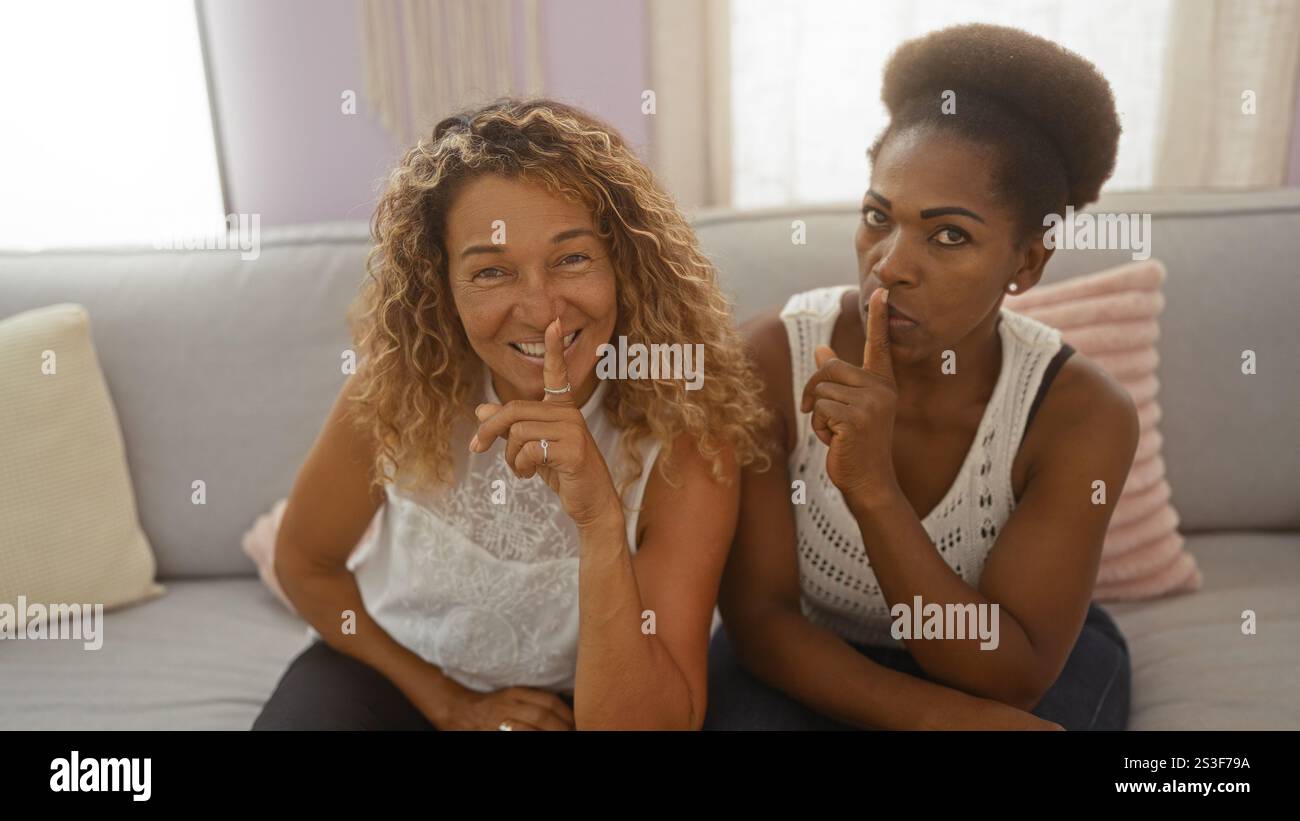 Women friends sharing a secret in a cozy living room, enjoying their ...