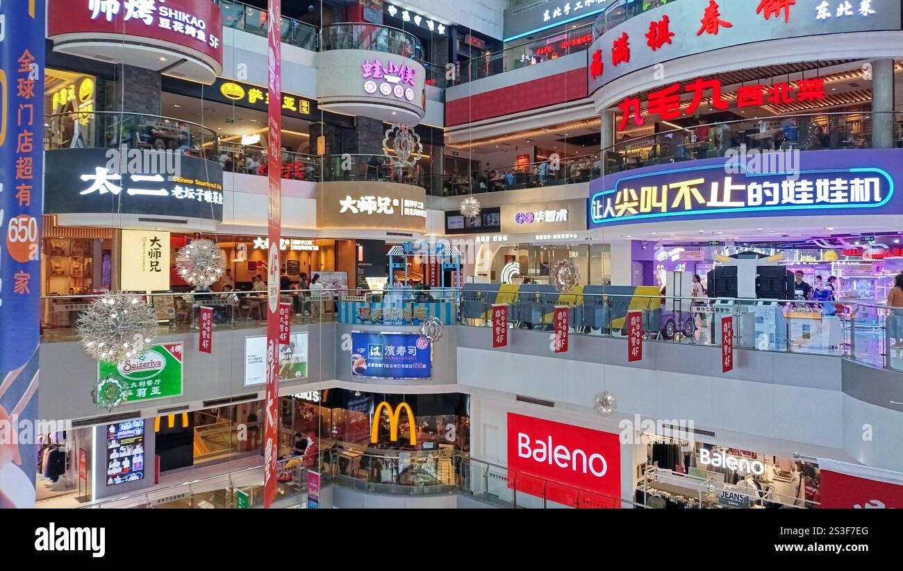 Canton, China - 20th October 2024: Modern shopping mall in TianHe district. Interior with neons ...