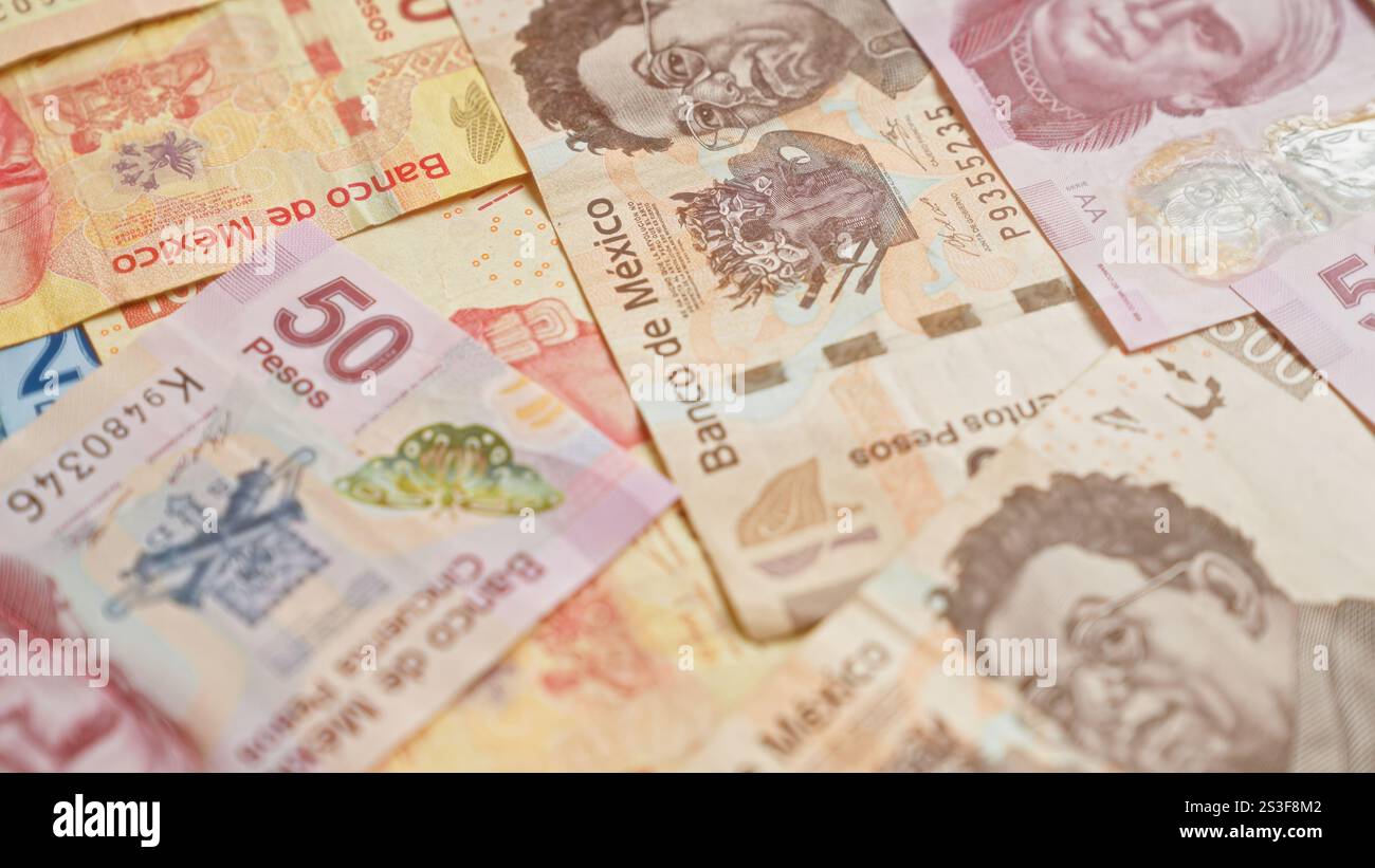 Mexican banknotes of various denominations scattered on a surface ...