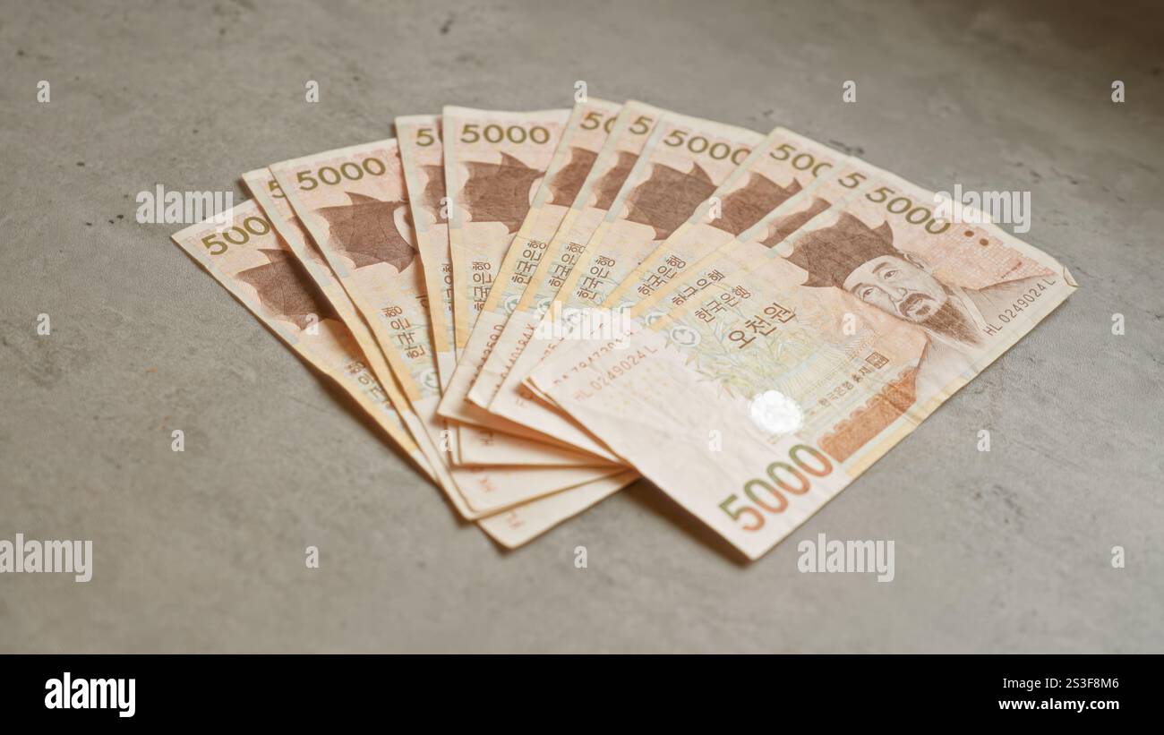 South korean banknotes neatly arranged on a concrete surface ...