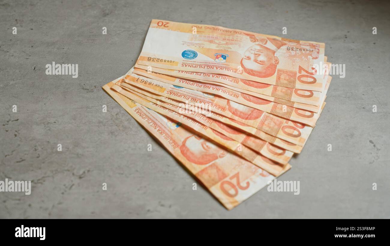 Philippine banknotes arranged on a concrete surface symbolize money ...