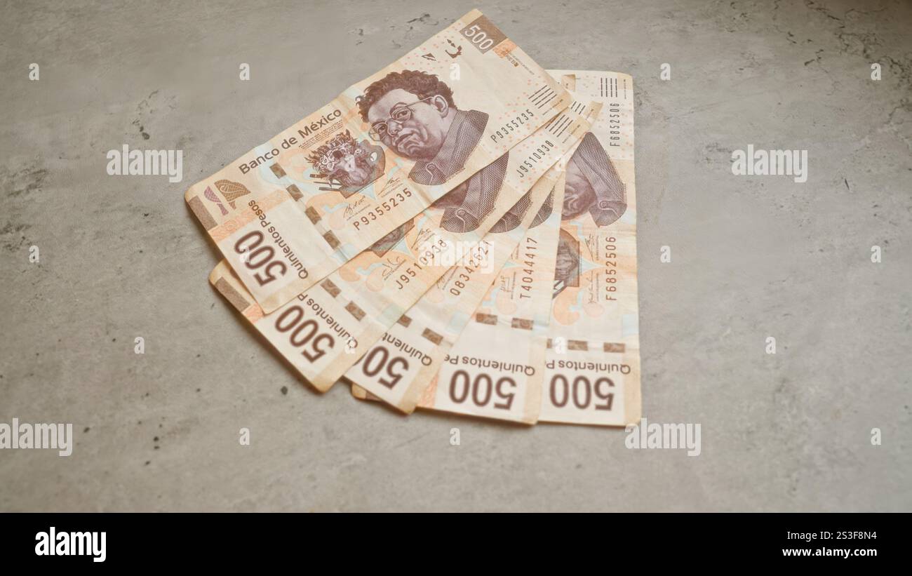 Mexican banknotes of 500 pesos fanned out on a gray concrete surface ...