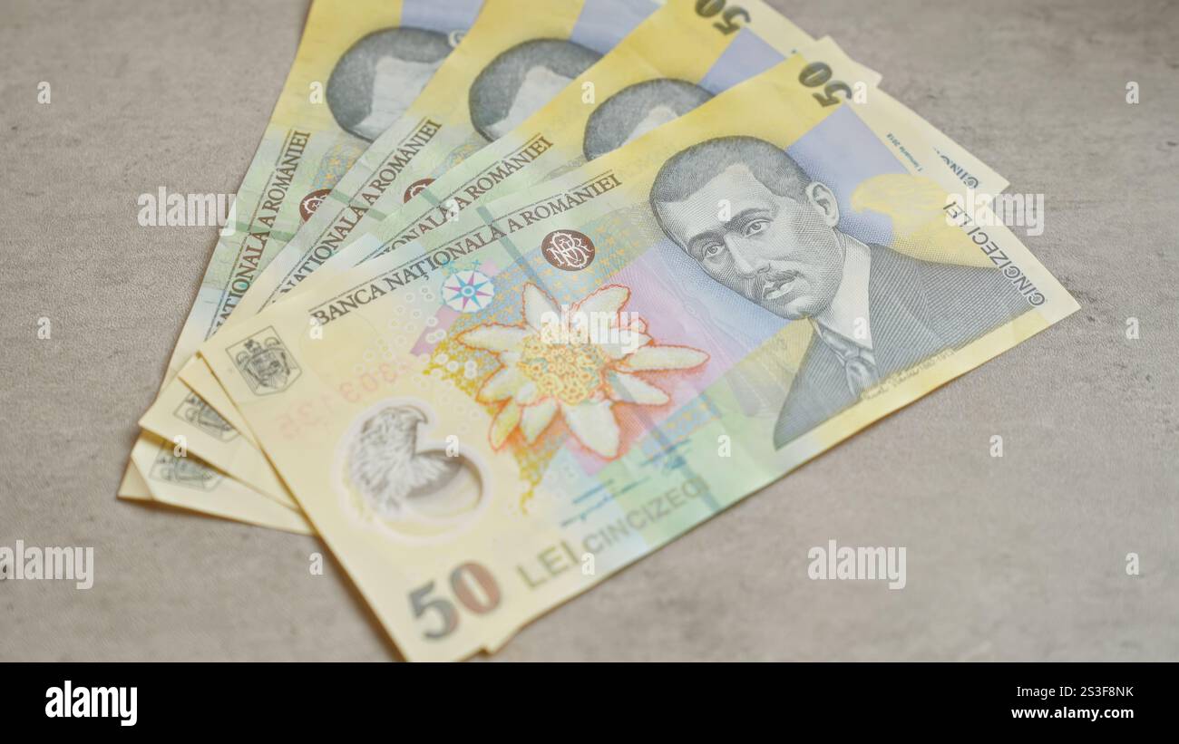 Romanian 50 leu banknotes arranged on a concrete surface showcasing the ...