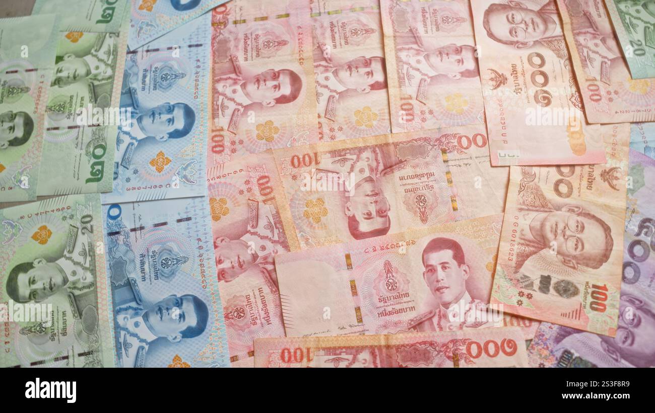 Colorful thai baht banknotes spread out in a close-up view, showcasing ...