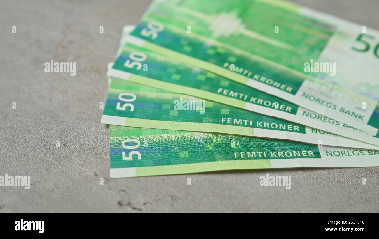 Norwegian banknotes of fifty kroner neatly arranged on a concrete ...