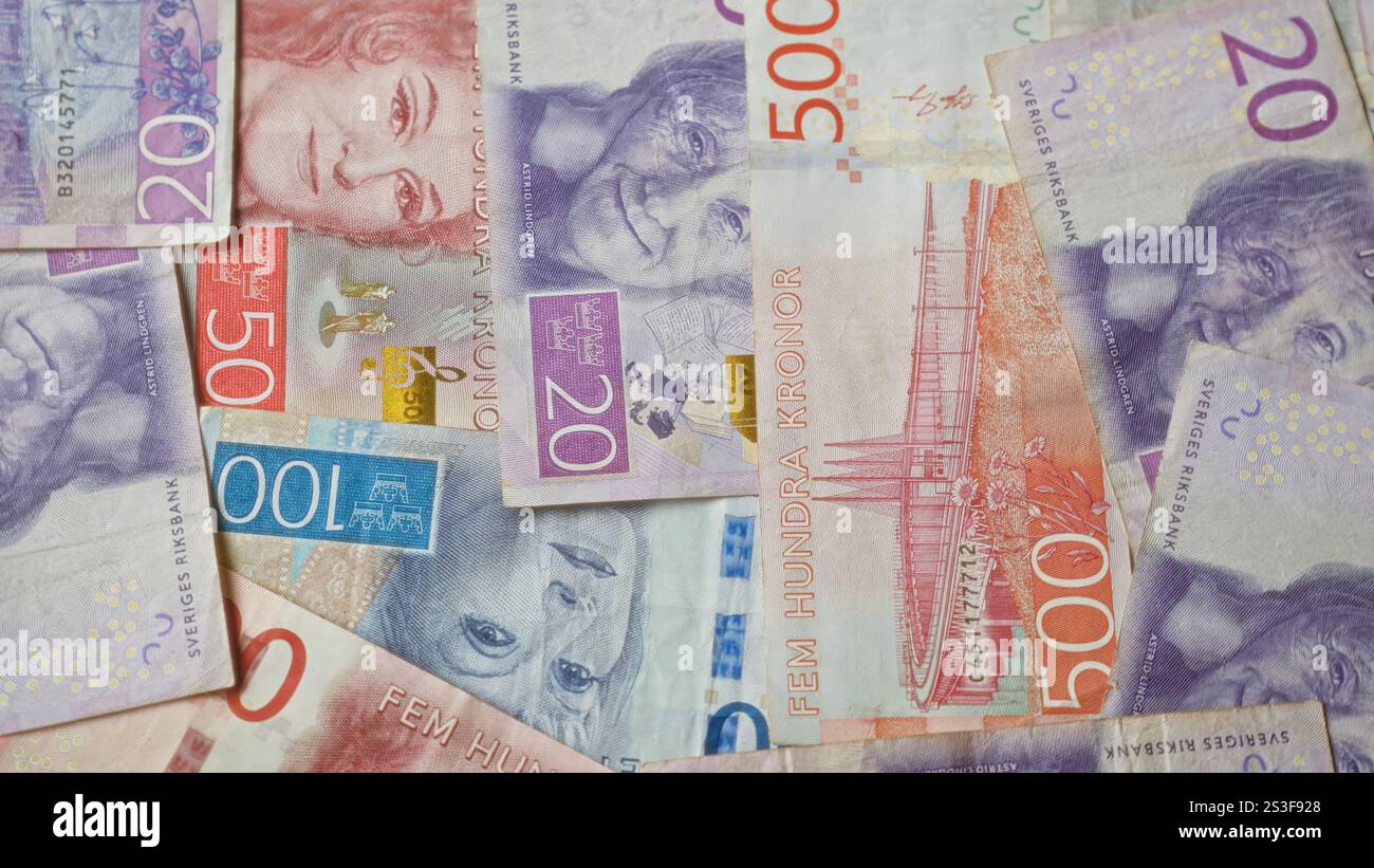 Swedish banknotes in various denominations of krona scattered on a flat ...
