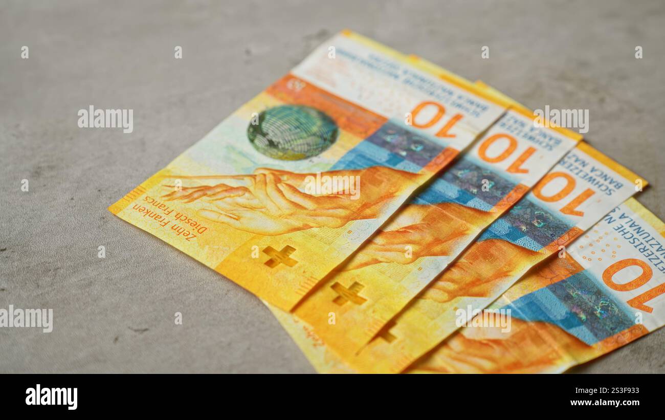 Four swiss francs banknotes lie on a concrete surface showcasing ...