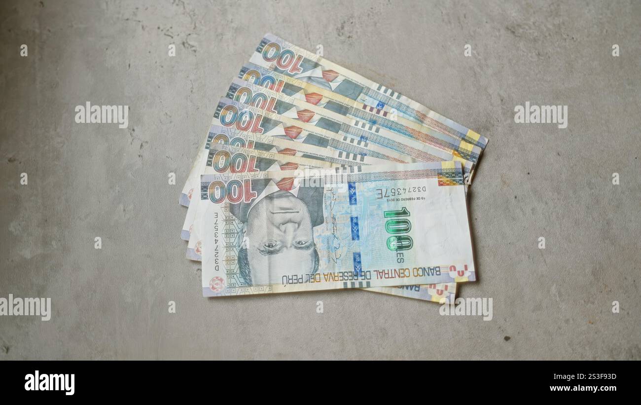 Peruvian banknotes arranged on a concrete surface, displaying various ...