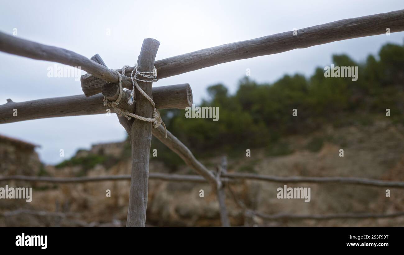 Wooden structure with ropes stands in an outdoor rural setting with a ...