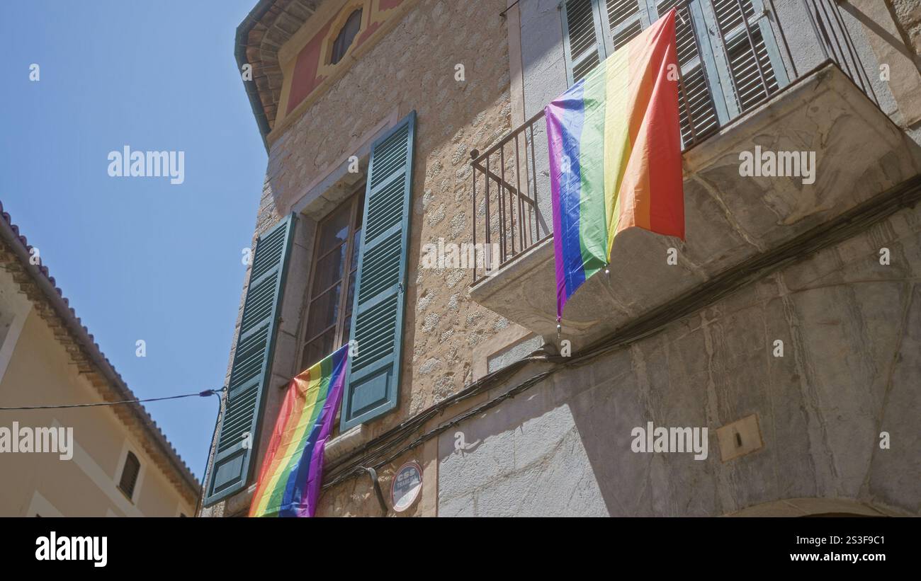 Colorful rainbow flags hanging from mediterranean-style building ...