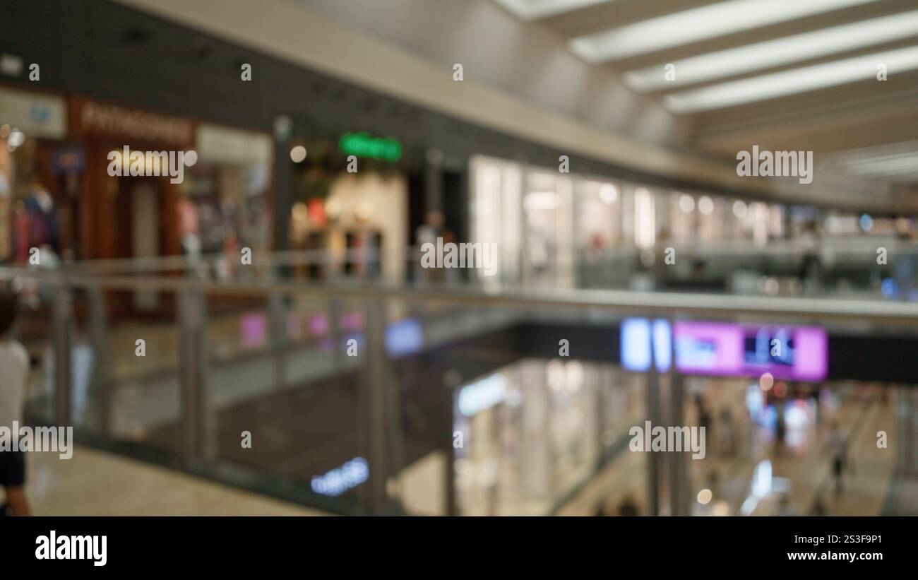 Blurred view of a modern shopping mall with defocused store fronts and ...