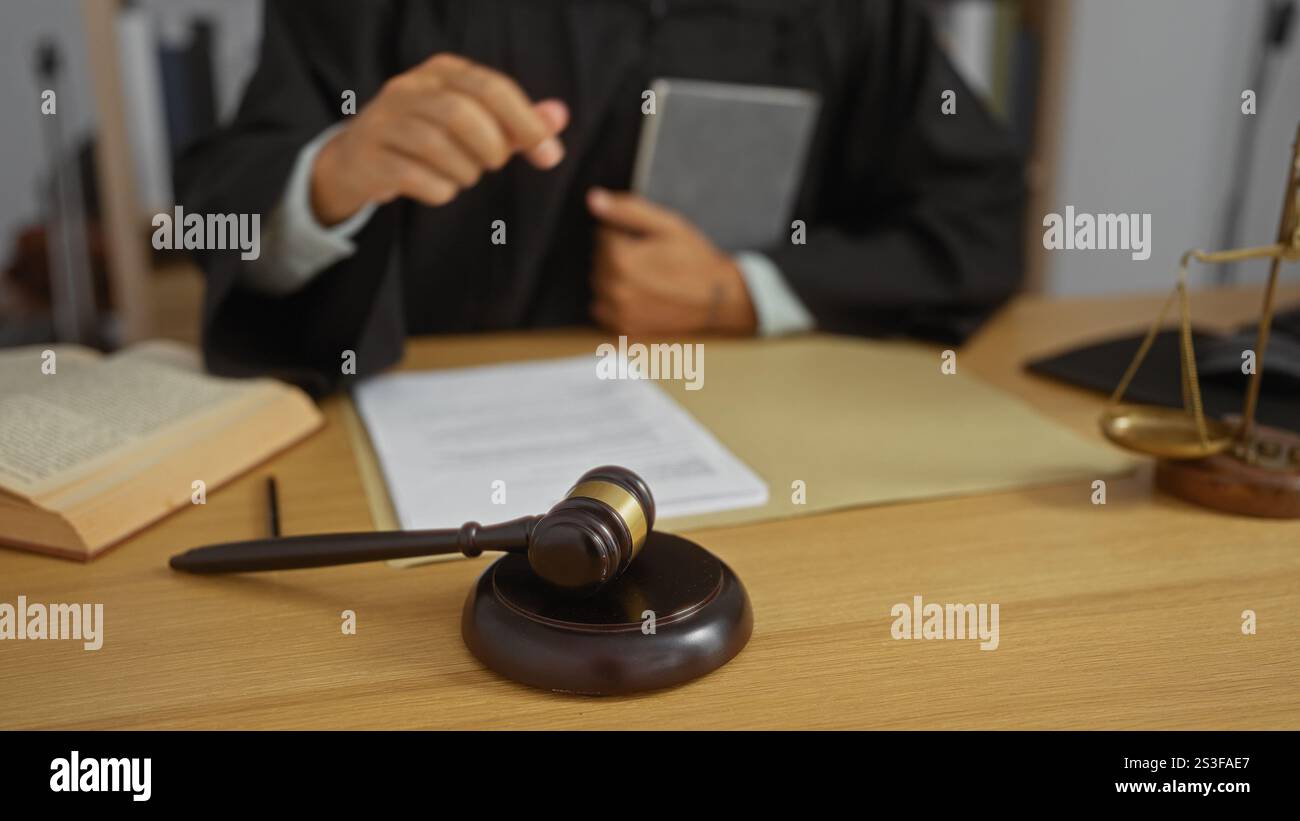 Judge holding book behind gavel in courtroom with legal documents and ...