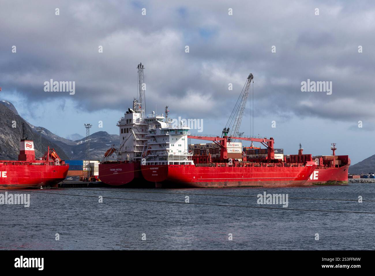 In the port of Nuuk, two red container ships are loaded wtih containers ...