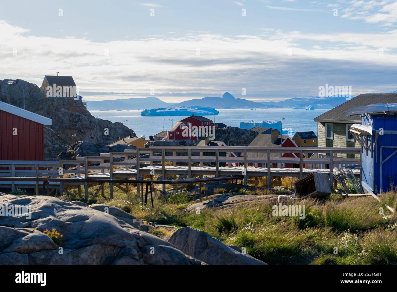 A typical wooden bridge in front of rocks with colourful houses ...