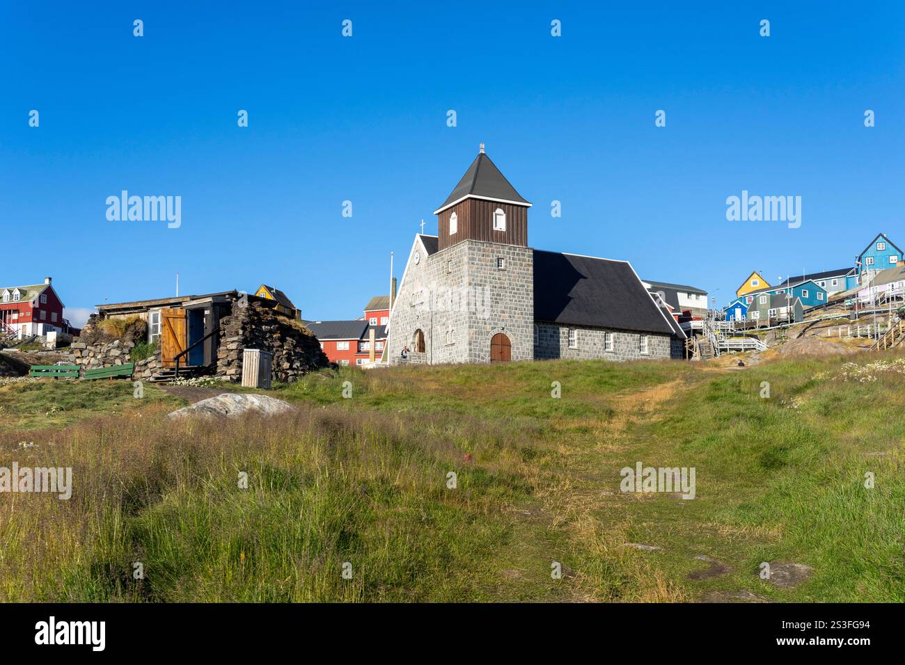 The church with its granite walls and a traditional peat house against ...