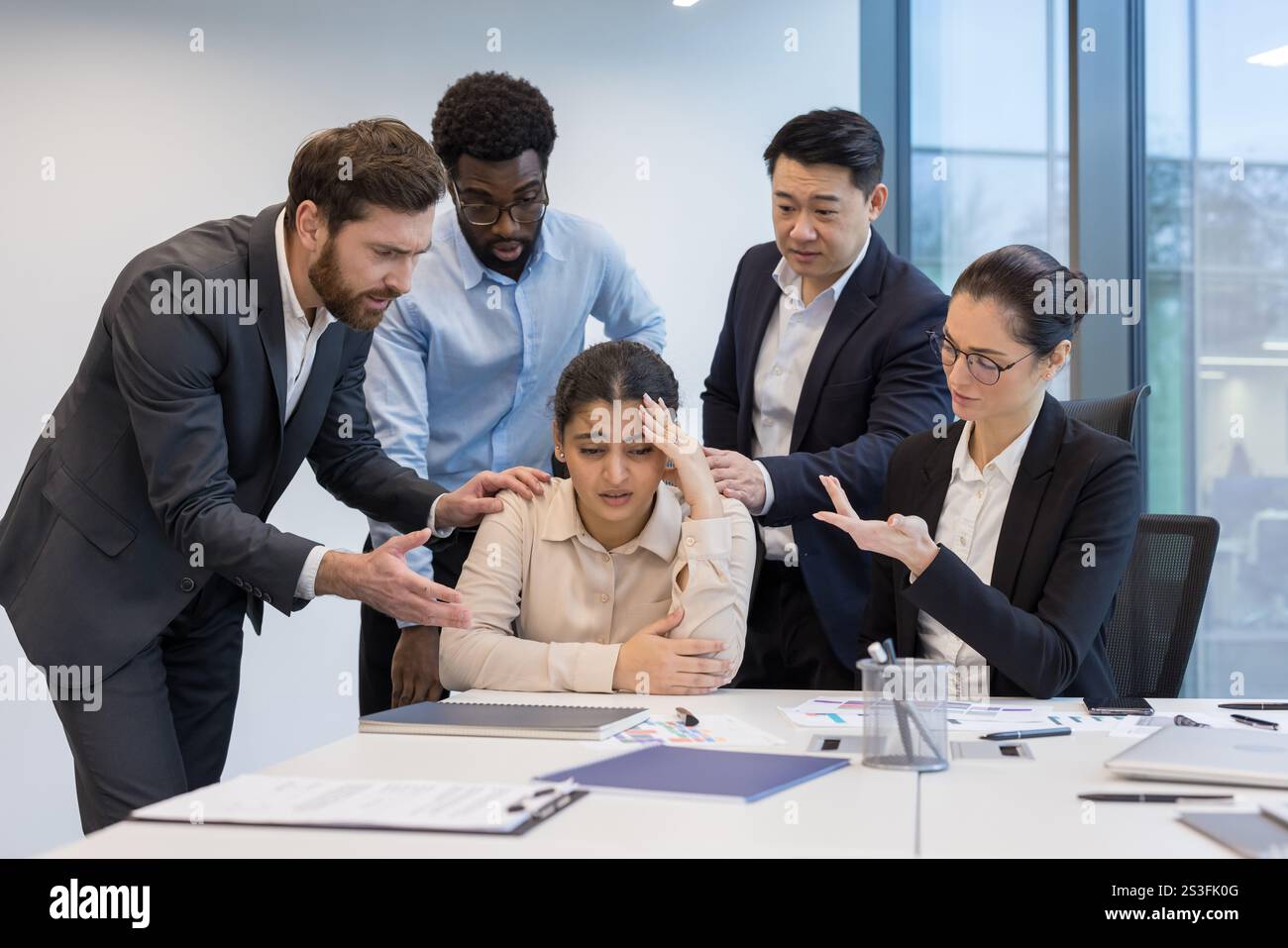 Colleagues support upset sad woman. Diverse business team at workplace ...