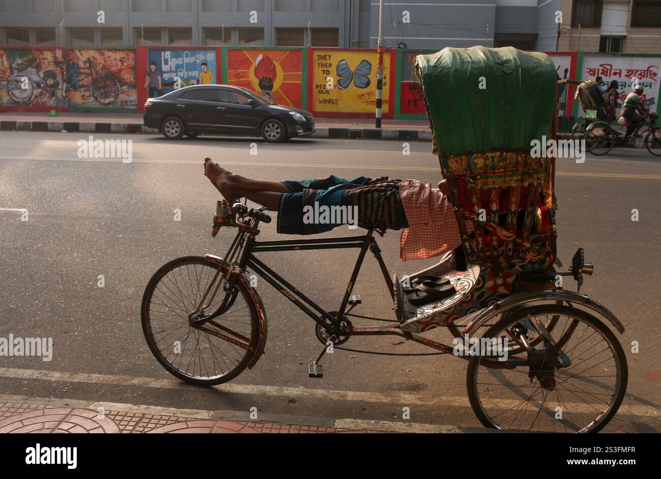 Dhaka, Dhaka, Bangladesh. 9th Jan, 2025. A rickshaw driver sleeping in his rickshaw on a street ...