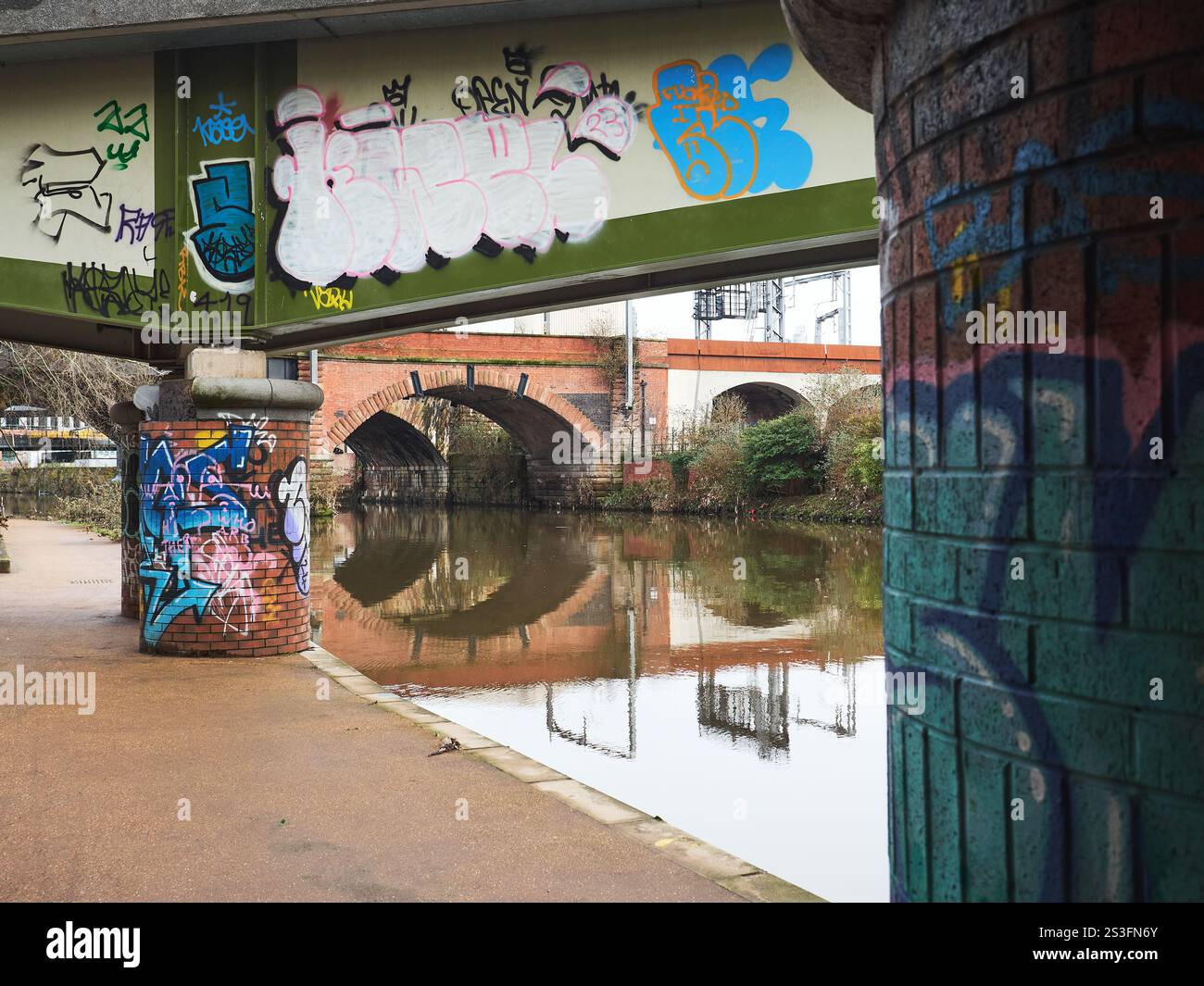 Salford , Manchester, UK, 01-04-2025: Graffiti-covered river underpass ...