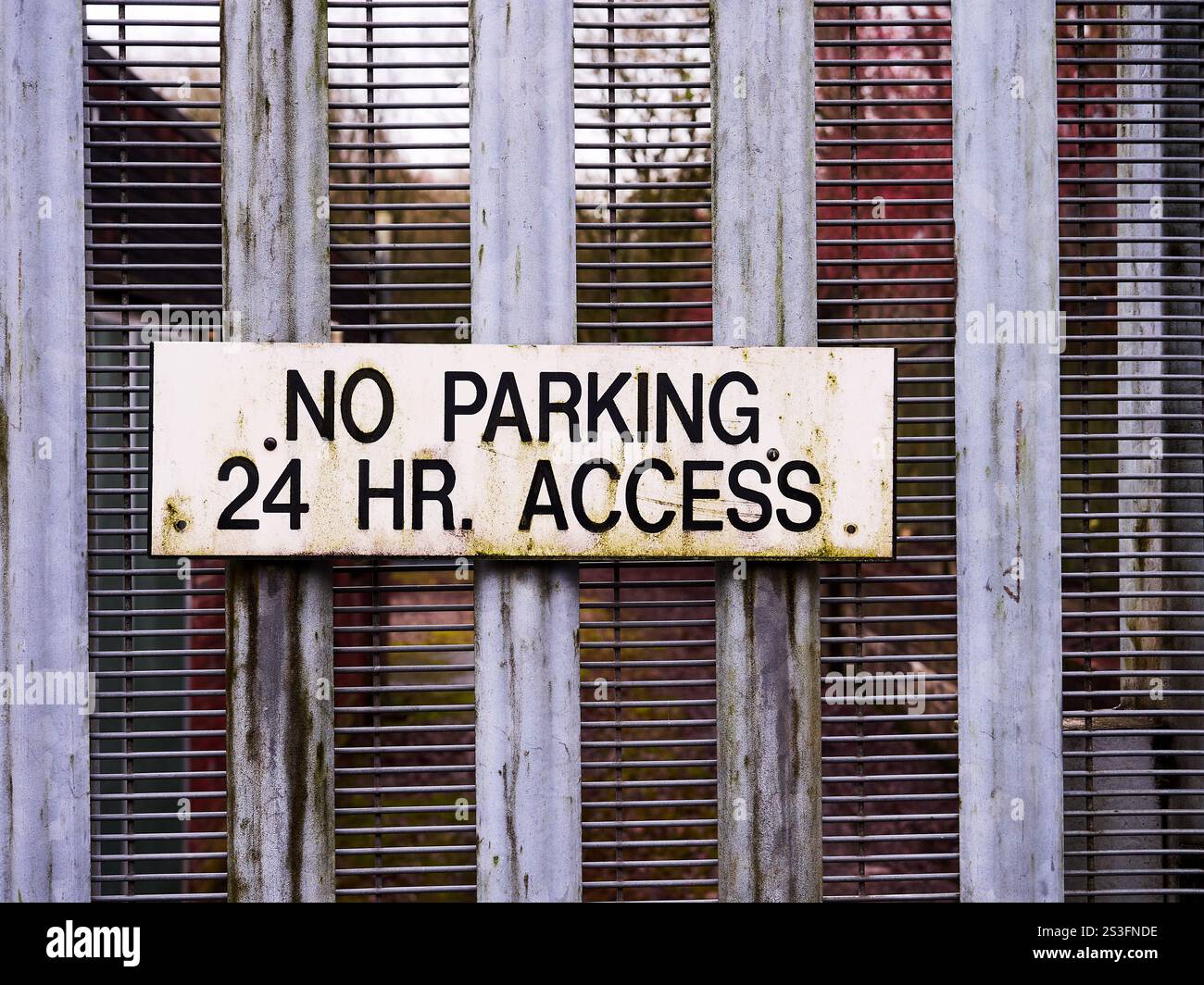 Weathered sign warning 'No Parking' on metal security fence Stock Photo ...