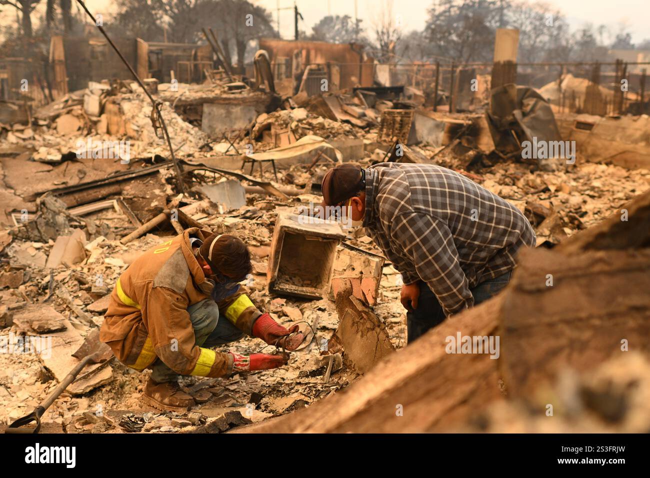 Robert Lara, left, looks for belongings along with his stepfather after ...