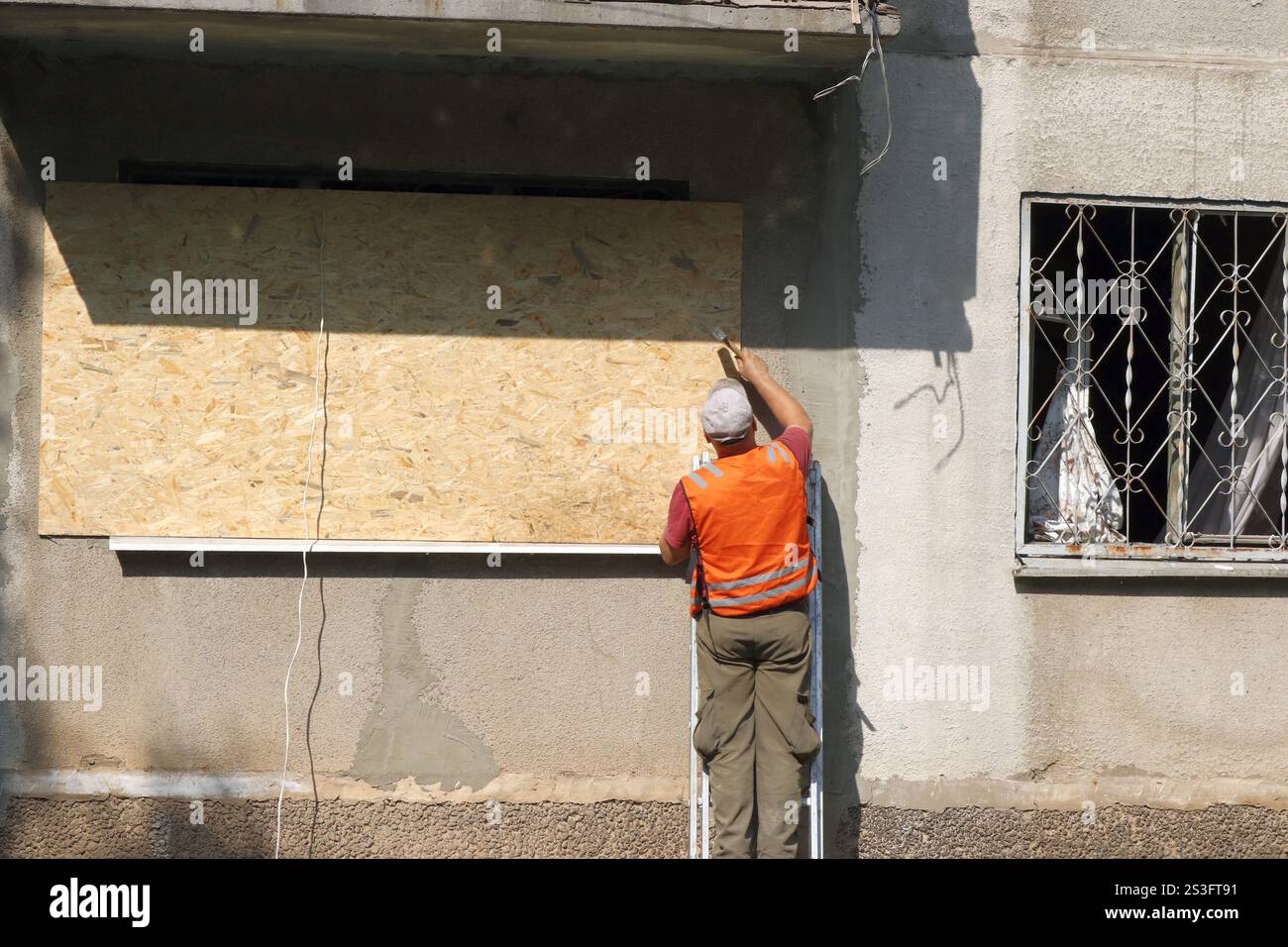 An apartment building with the aftermath of a rocket attack and ...