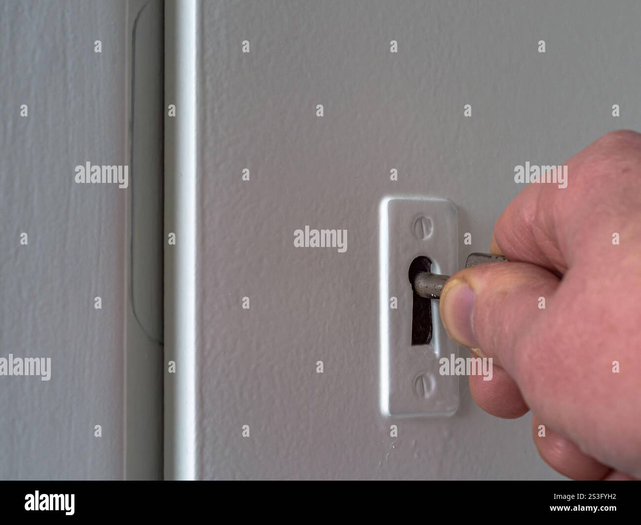 male hand puts key in keyhole of white door Stock Photo - Alamy