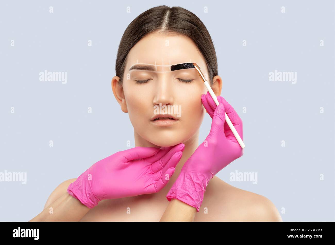 Make-up artist makes markings with white pencil for eyebrow and paints ...