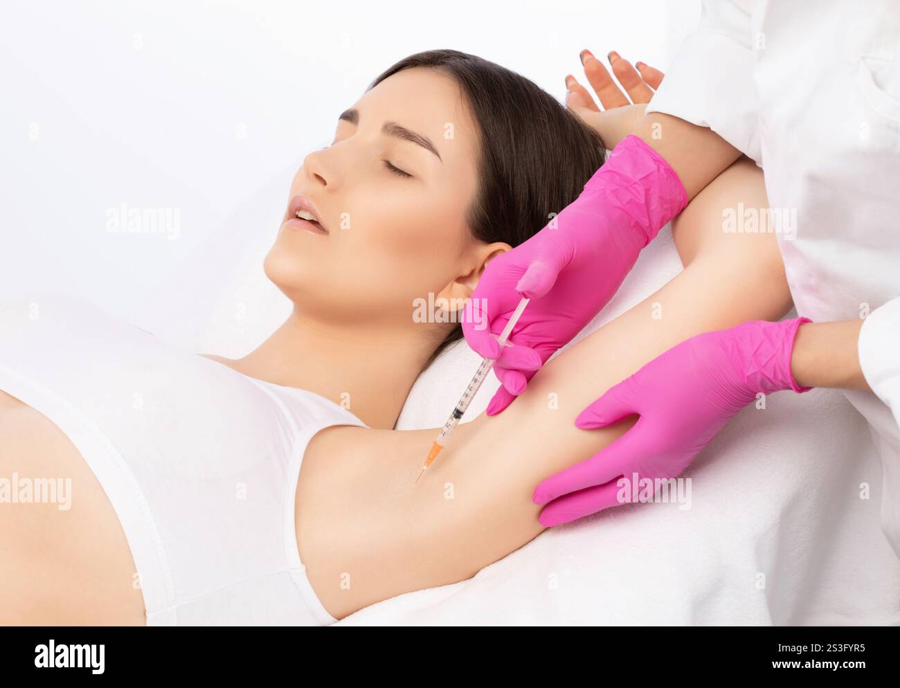 The doctor makes injections of botulinum toxin in the underarm area ...