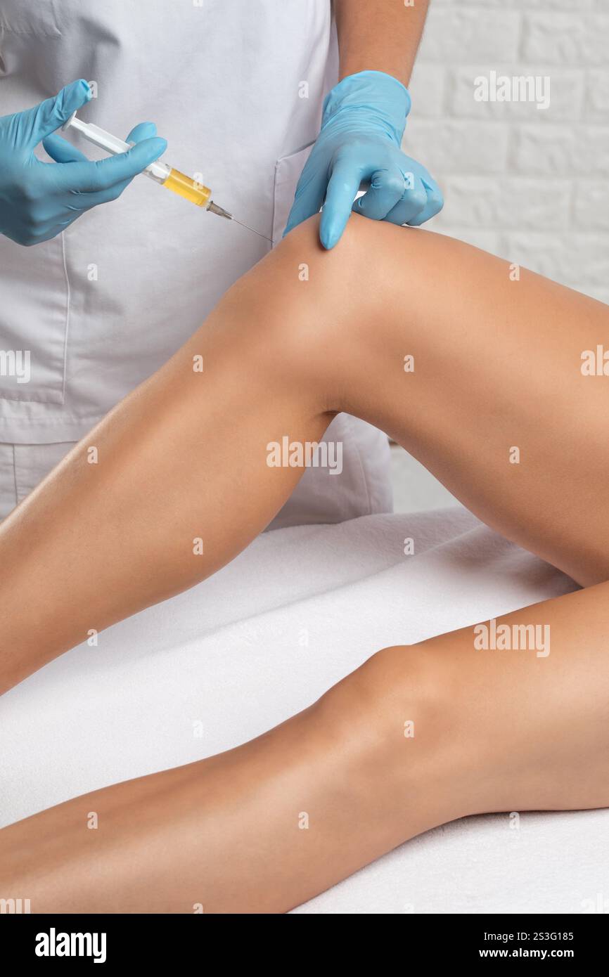 Doctor doing stem cell therapy on a patient's knee after the injury. Treating knee pain with ...