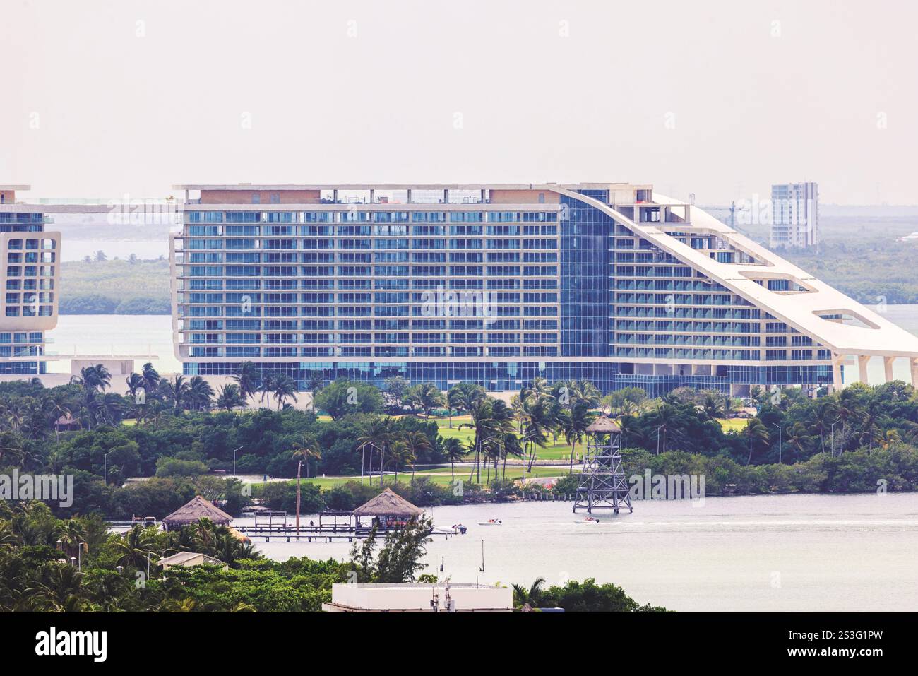 Modern luxury resort building surrounded by lush greenery near lagoon ...