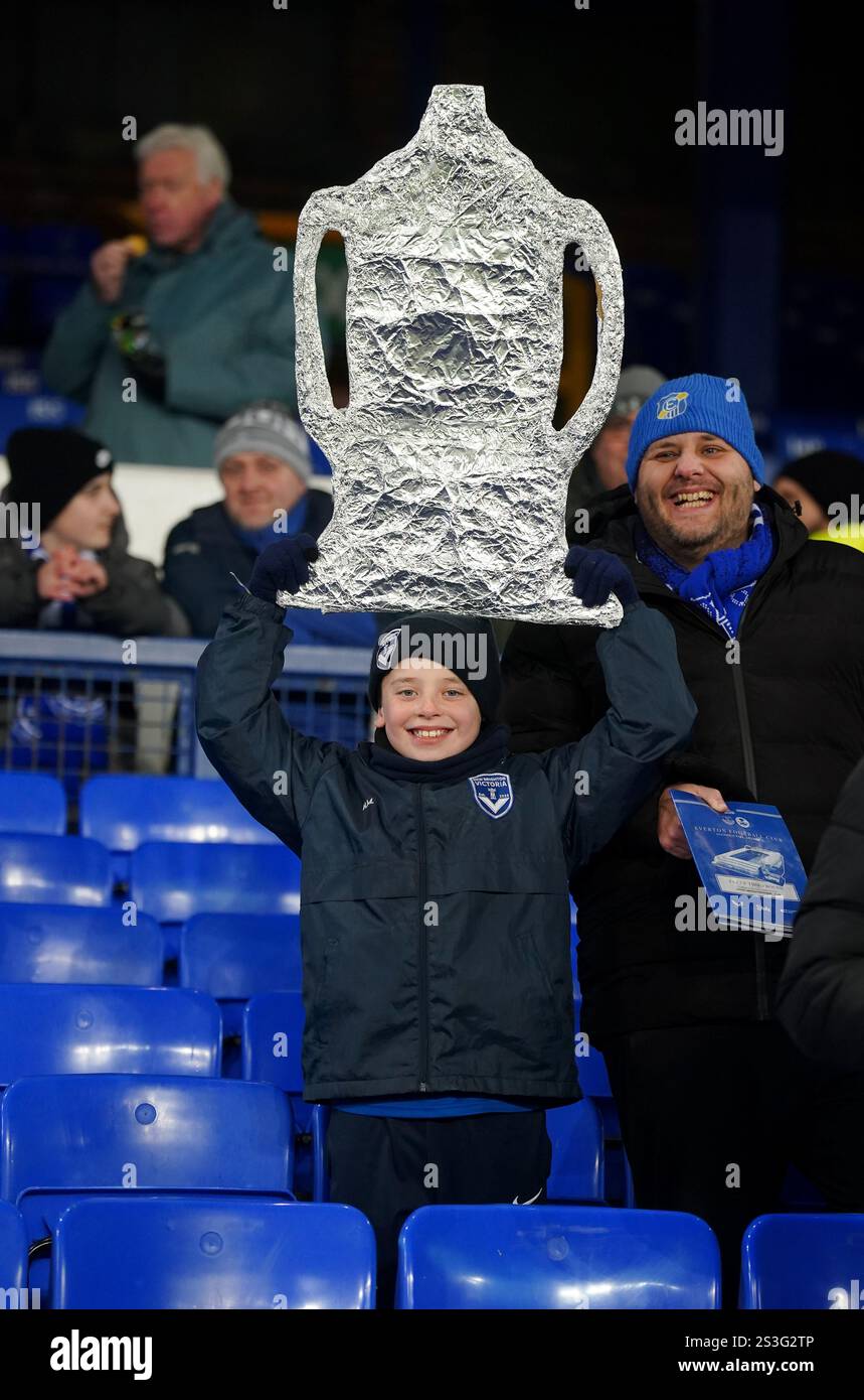A young Everton fan holding a tin foil trophy in the stands before the ...