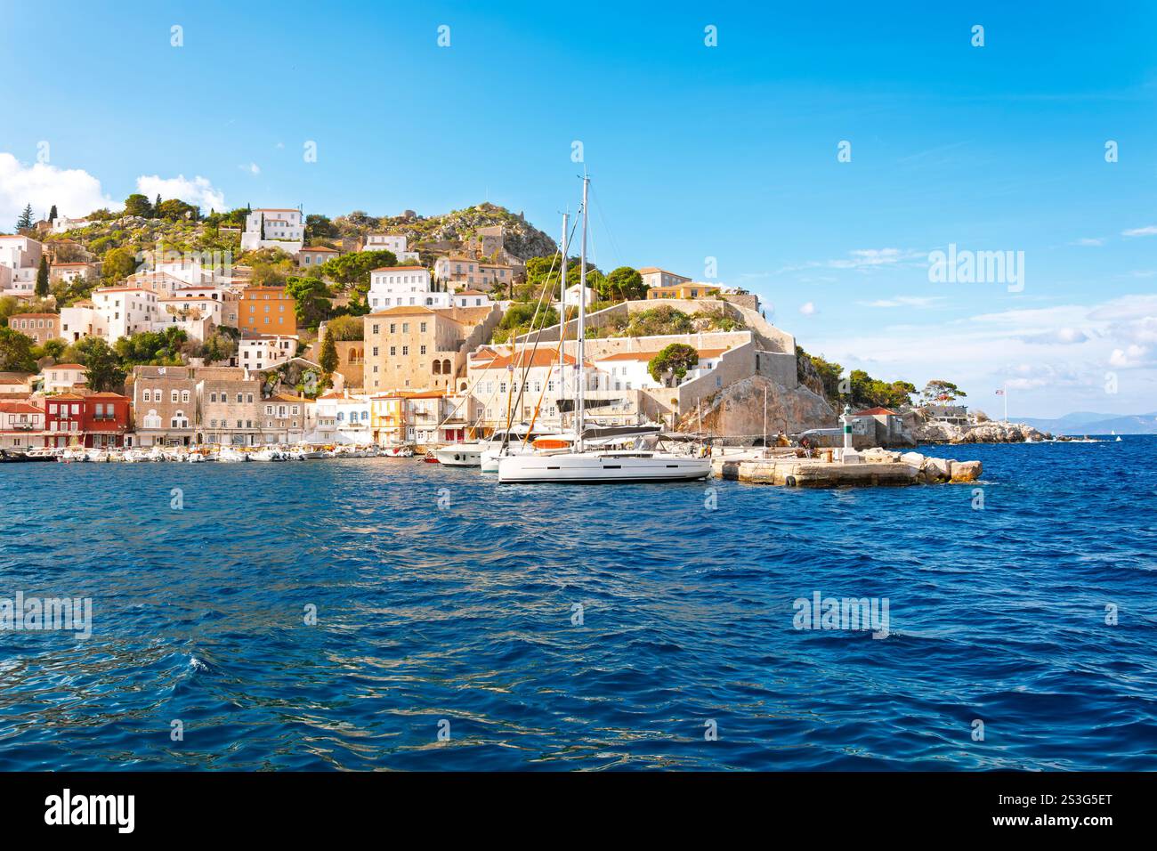 Boats at the pier with colorful and historic stone buildings along the ...