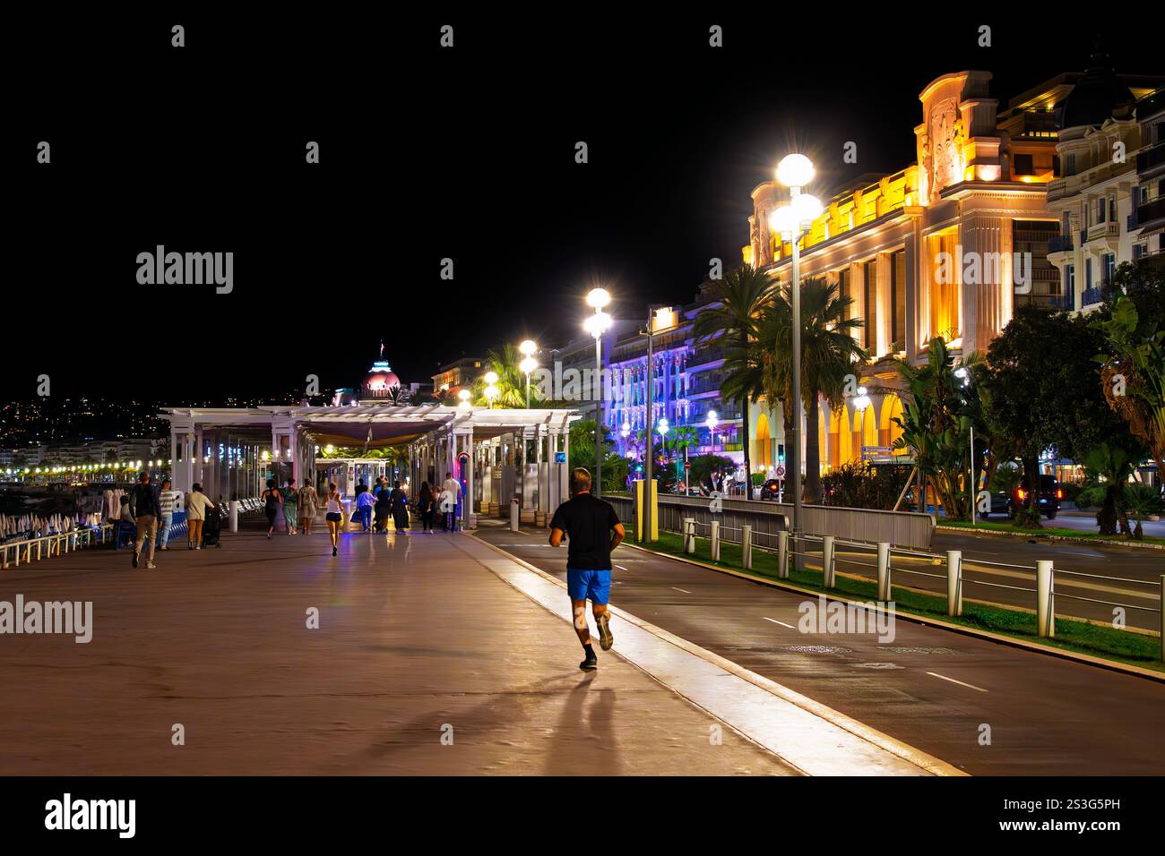 Night view of joggers and pedestrians enjoying a mild evening on the ...
