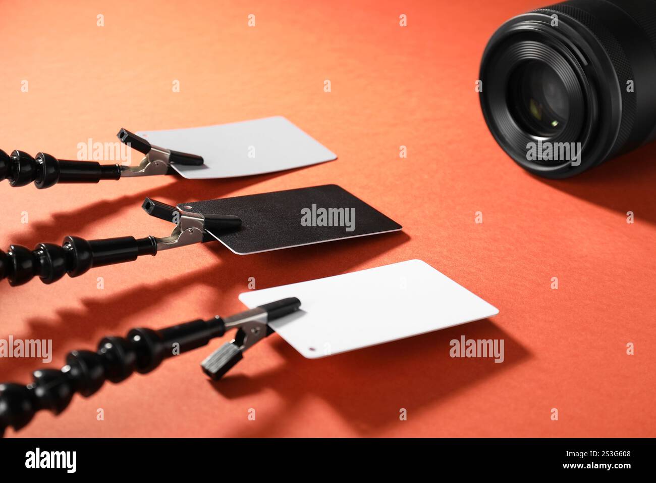 White balance calibration cards and camera on red background, closeup ...