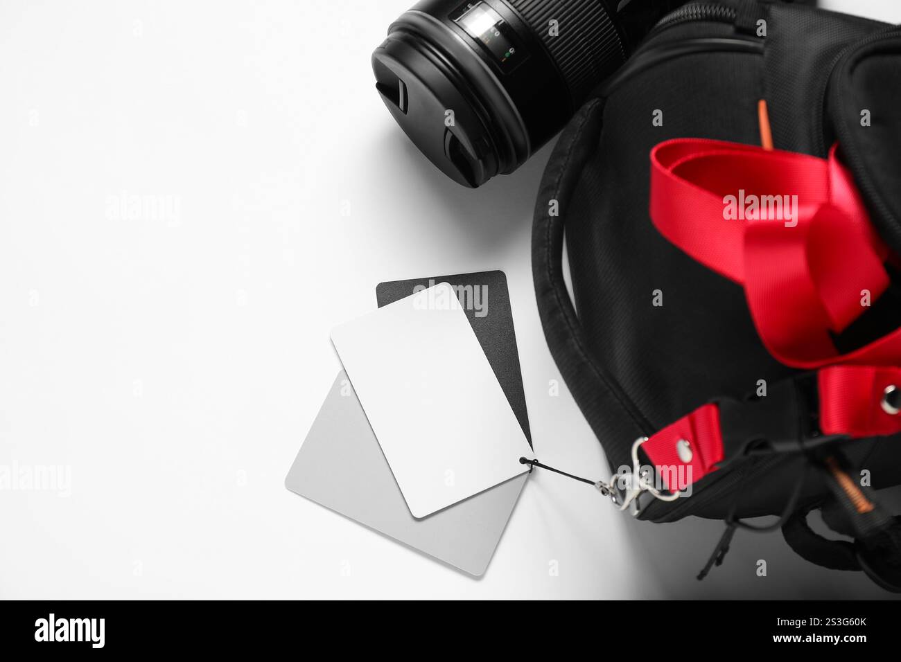 White balance calibration cards, camera and bag on white background ...