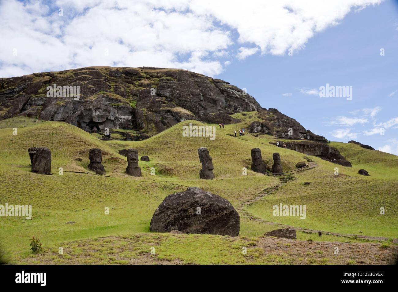Tourists walk a trail past Moai at Rano Raraku, the quarry where they ...