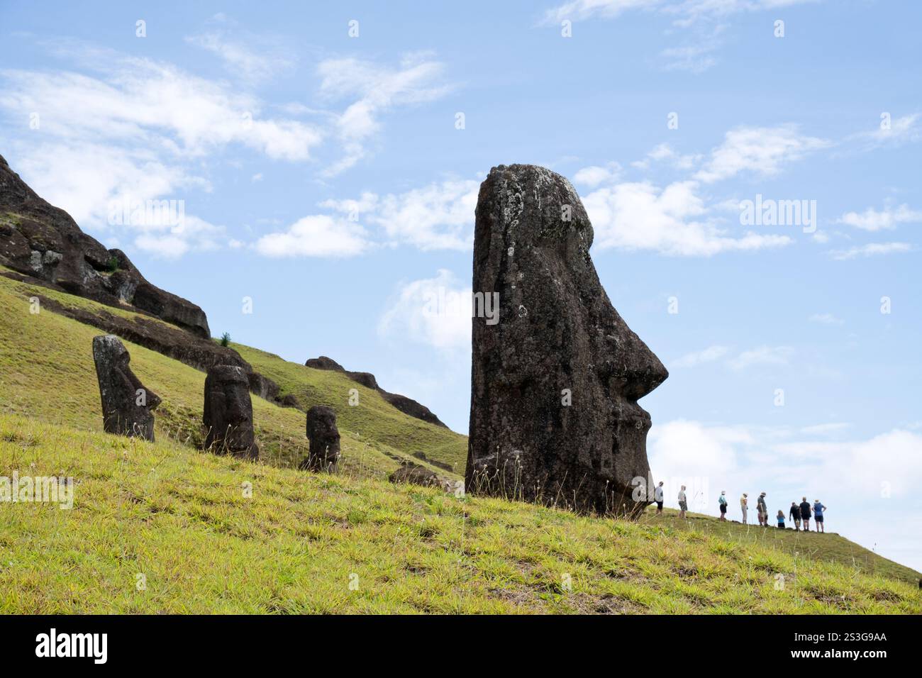 Tourists walk a trail past Moai at Rano Raraku, the quarry where they ...