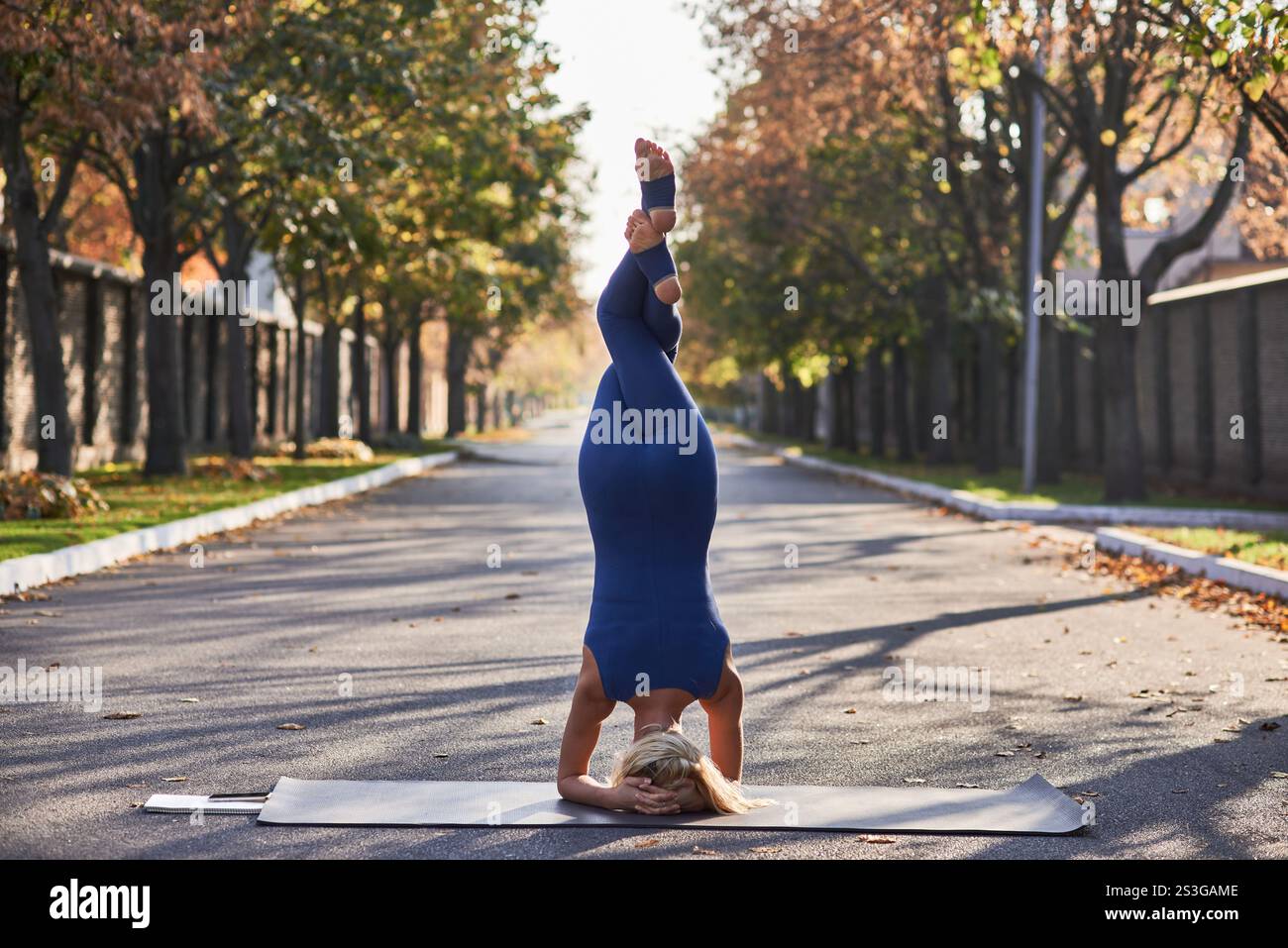 Outdoor yoga woman in headstand, serene morning park setting, peaceful ...