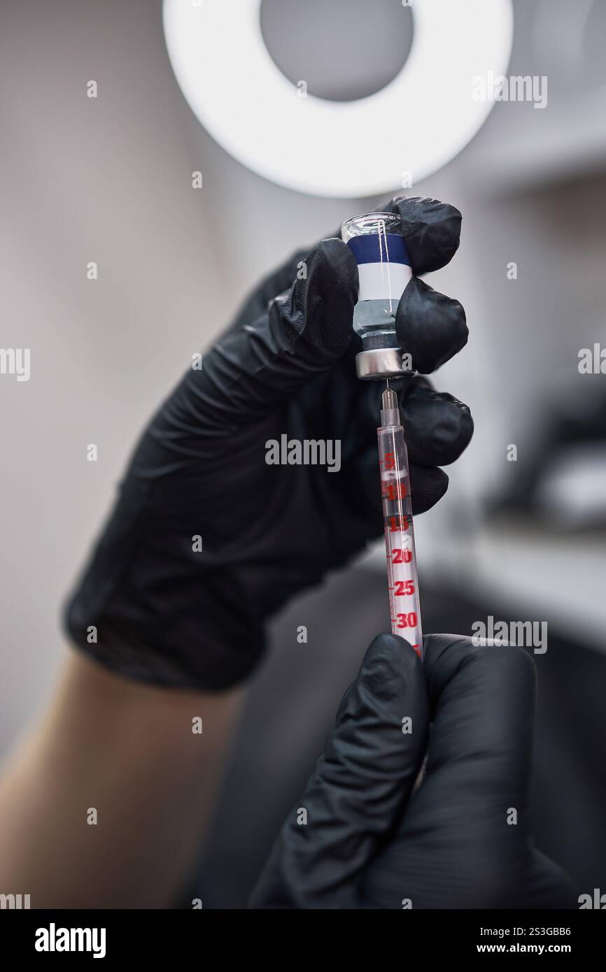 In lab setting, precise dosage preparation filling syringe with ...