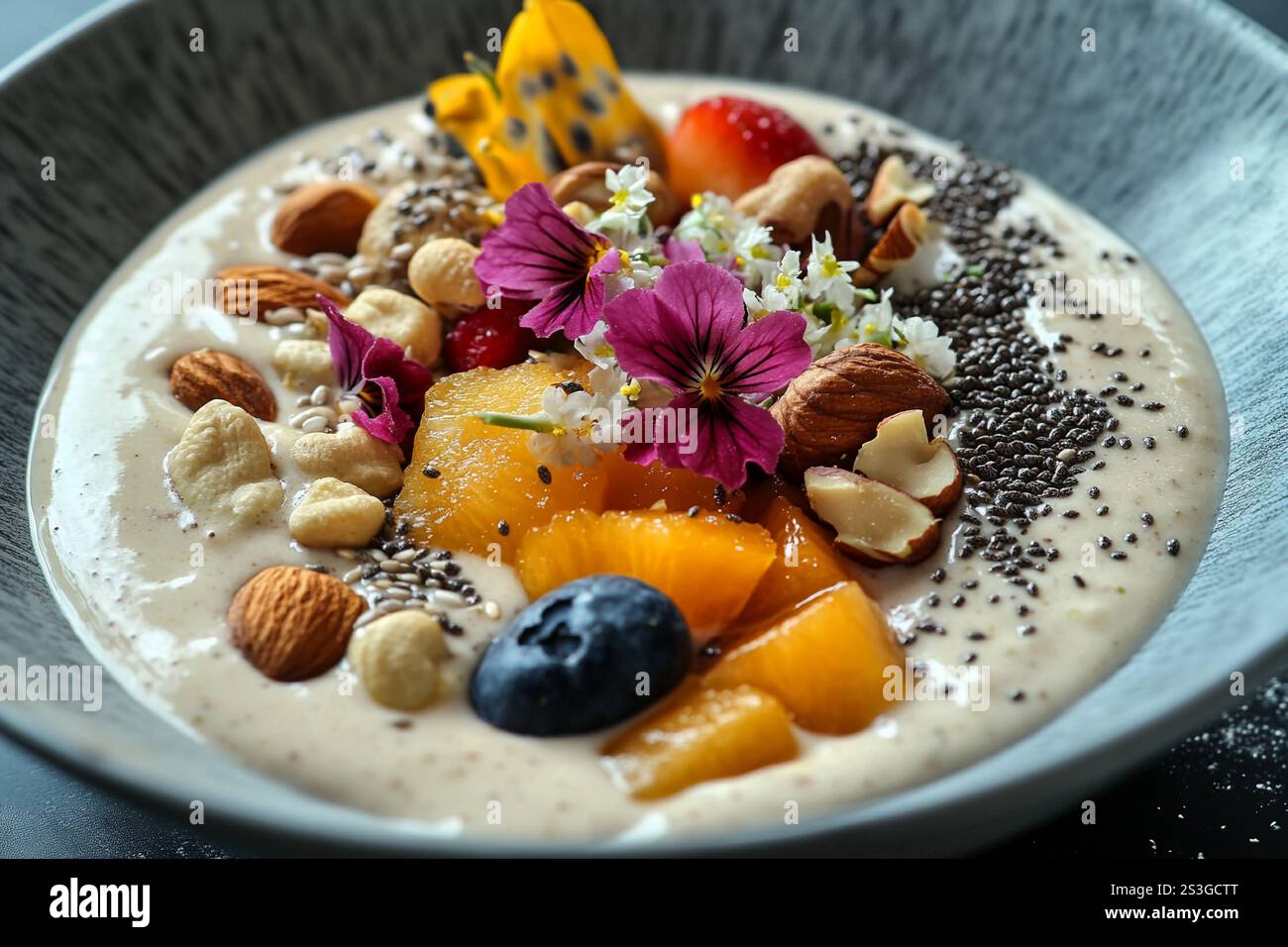 Smoothie bowl features a creamy base topped with fresh fruits, nuts ...